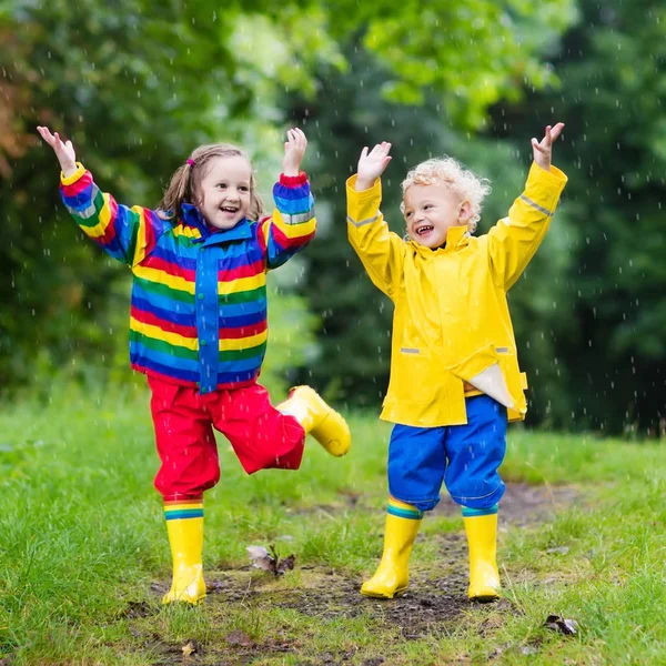 Kids play in rain and puddle in autumn Stock Photo by ©FamVeldman 151866704