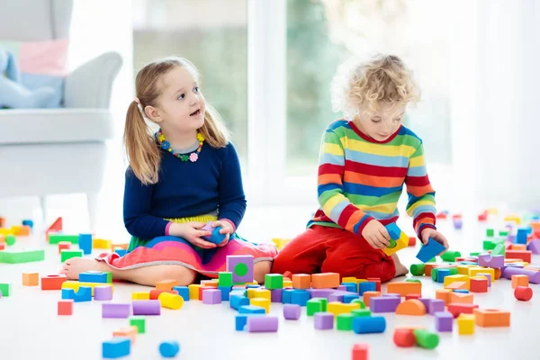 Kids playing with colorful toy blocks — Stock Photo © FamVeldman #117913846