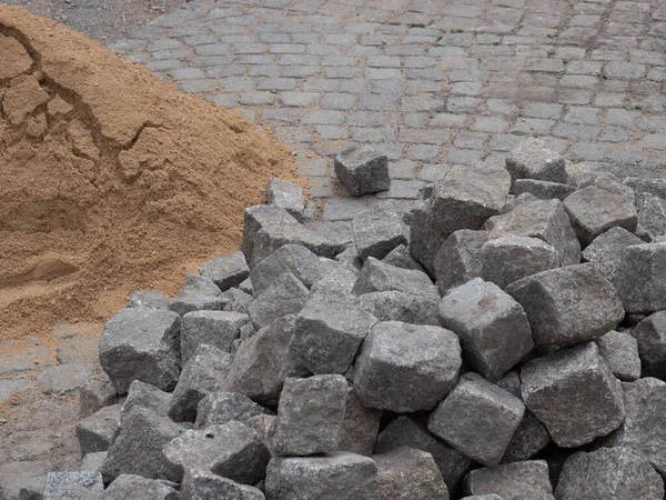 Paving stones and piles of sand road construction - Stock Image ...
