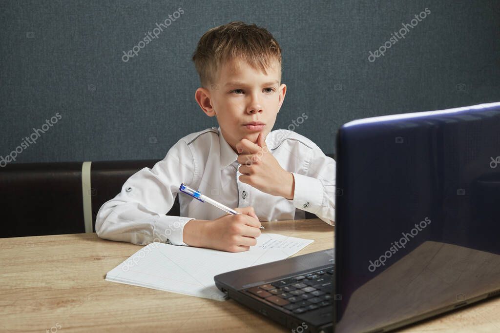 Un chico que usa el portátil para hacer los deberes. El niño se queda ...