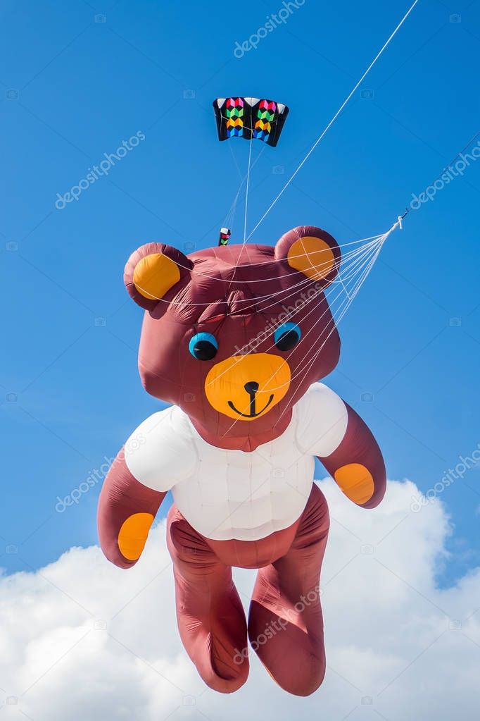 Bonita cometa en forma de oso y cielo nublado azul 2023