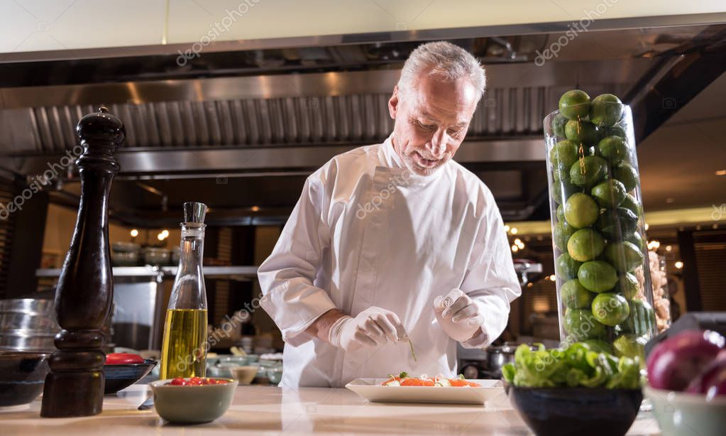 Chef sonriente decorando el plato en la cocina 2023