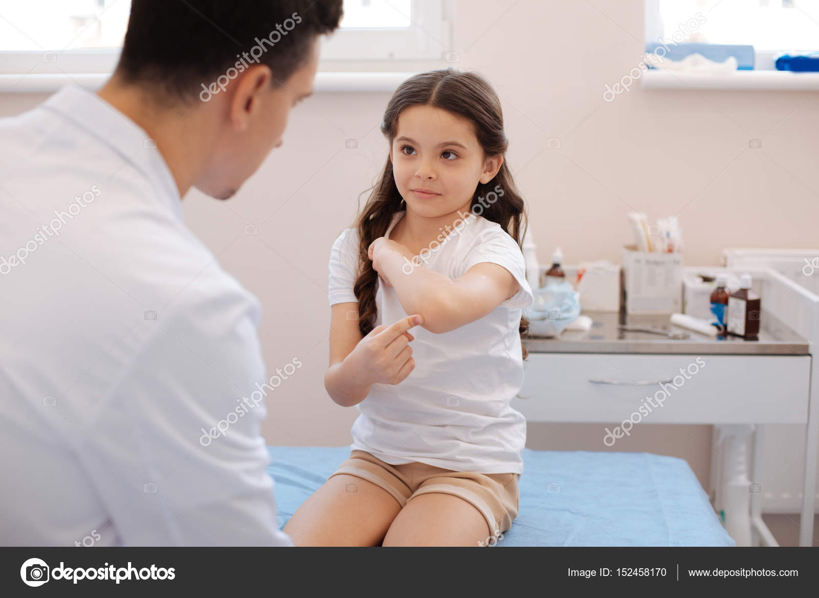 Pleasant pretty girl pointing at her elbow — Stock Photo © yacobchuk1 ...