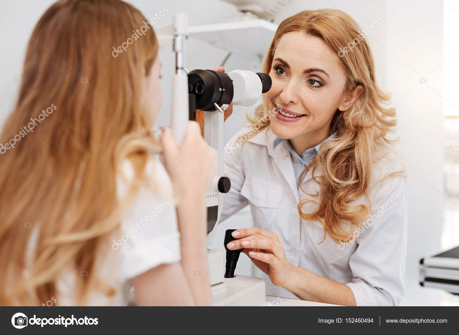 Friendly ophthalmologist explaining how equipment works Stock Photo by ...