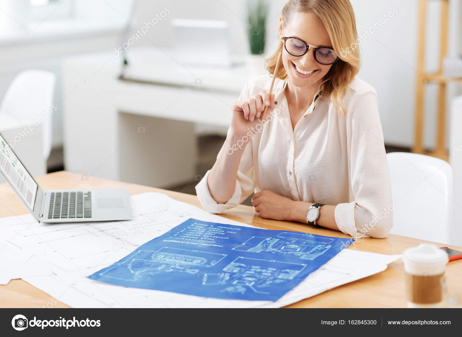 Delightful architect exploring engineering scheme in the office — Stock Photo © yacobchuk1 ...