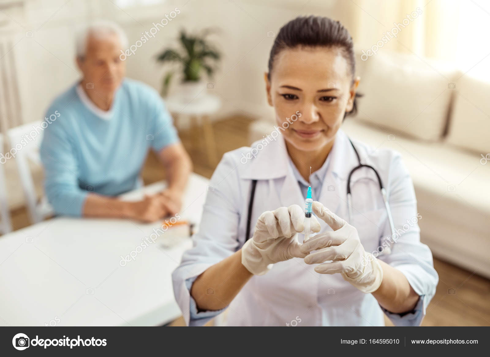 Cheerful positive nurse testing the syringe — Stock Photo © yacobchuk1 ...
