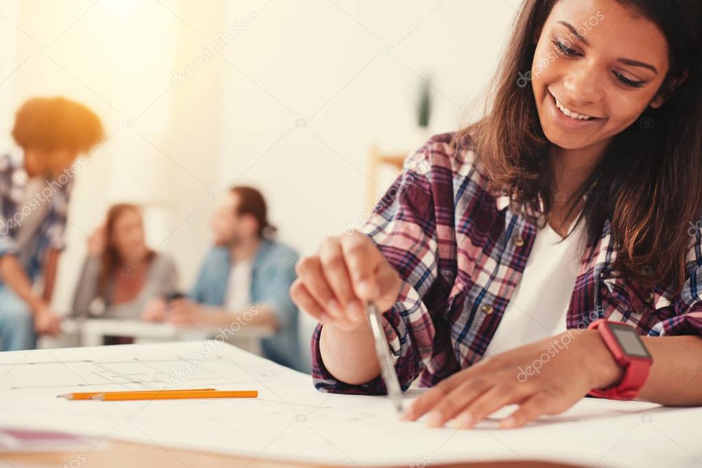 Estudiante sonriente midiendo la distancia en su gráfico 2024