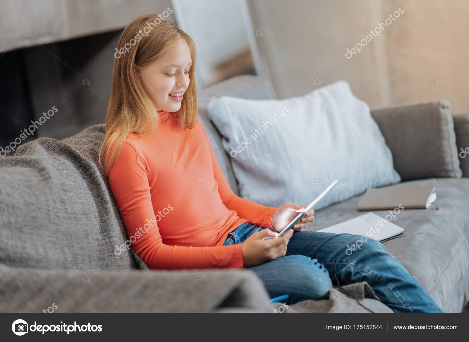 Positive nice girl sitting on the sofa Stock Photo by ©yacobchuk1 175152844
