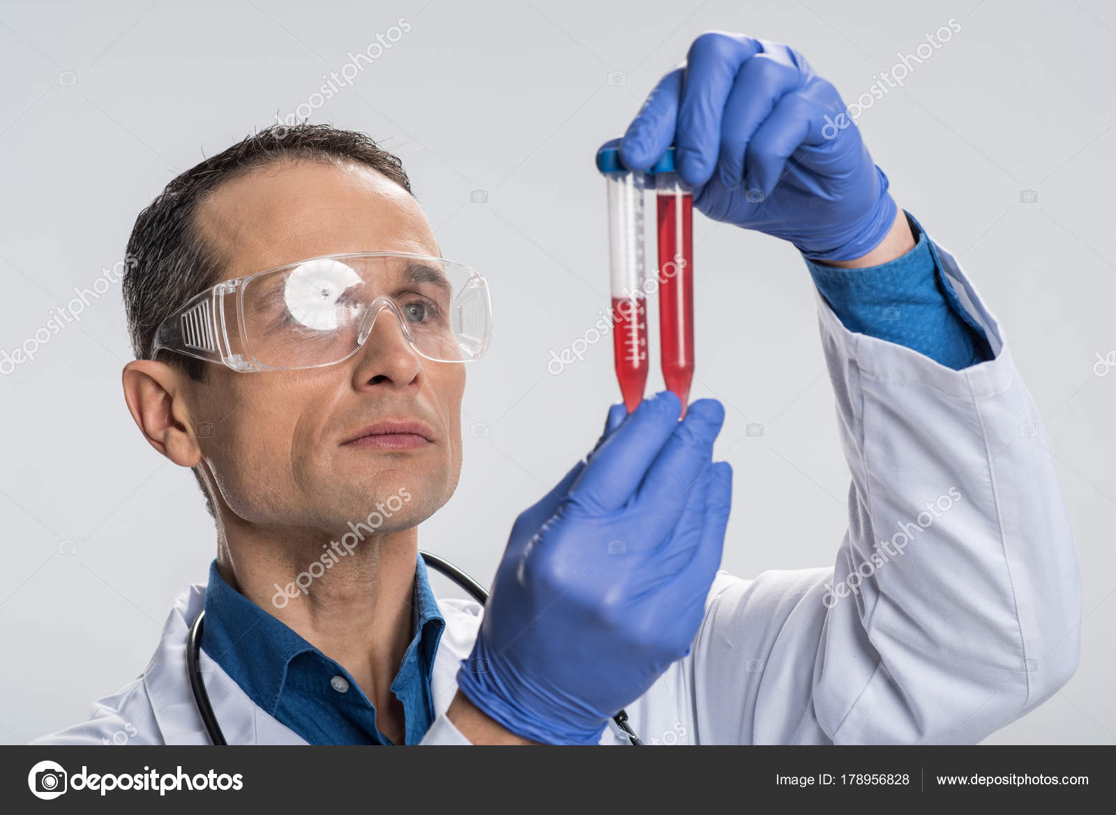 Elegant male laboratorian scrutinizing blood sample Stock Photo by ...