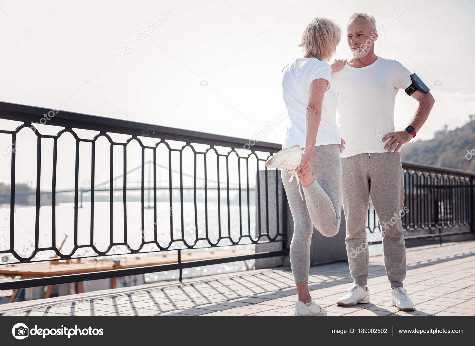 Handsome confident man standing and supporting a woman. Stock Photo by ...