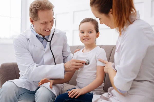 Two prominent doctors taking care of their little patient - Stock Image ...
