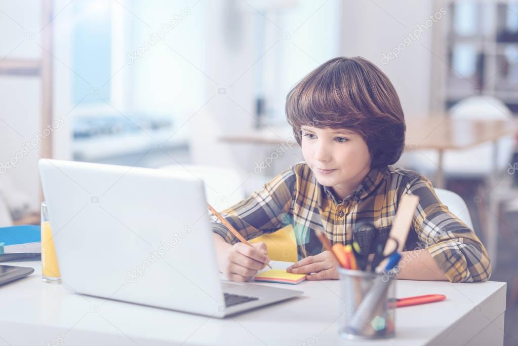 niño tomando notas mientras estudia 2023