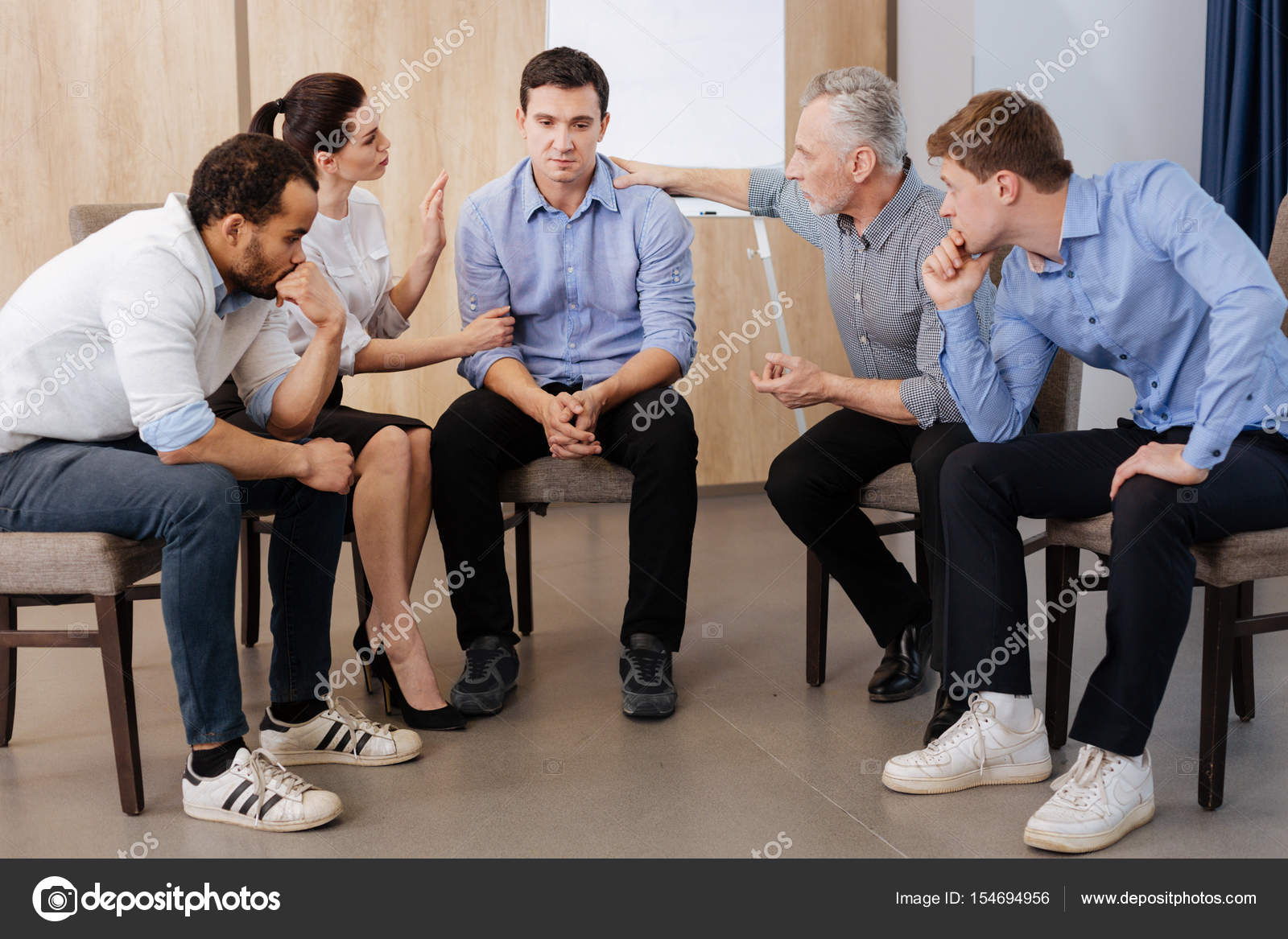 Friendly sympathetic people supporting a sad man Stock Photo by ©Dmyrto ...