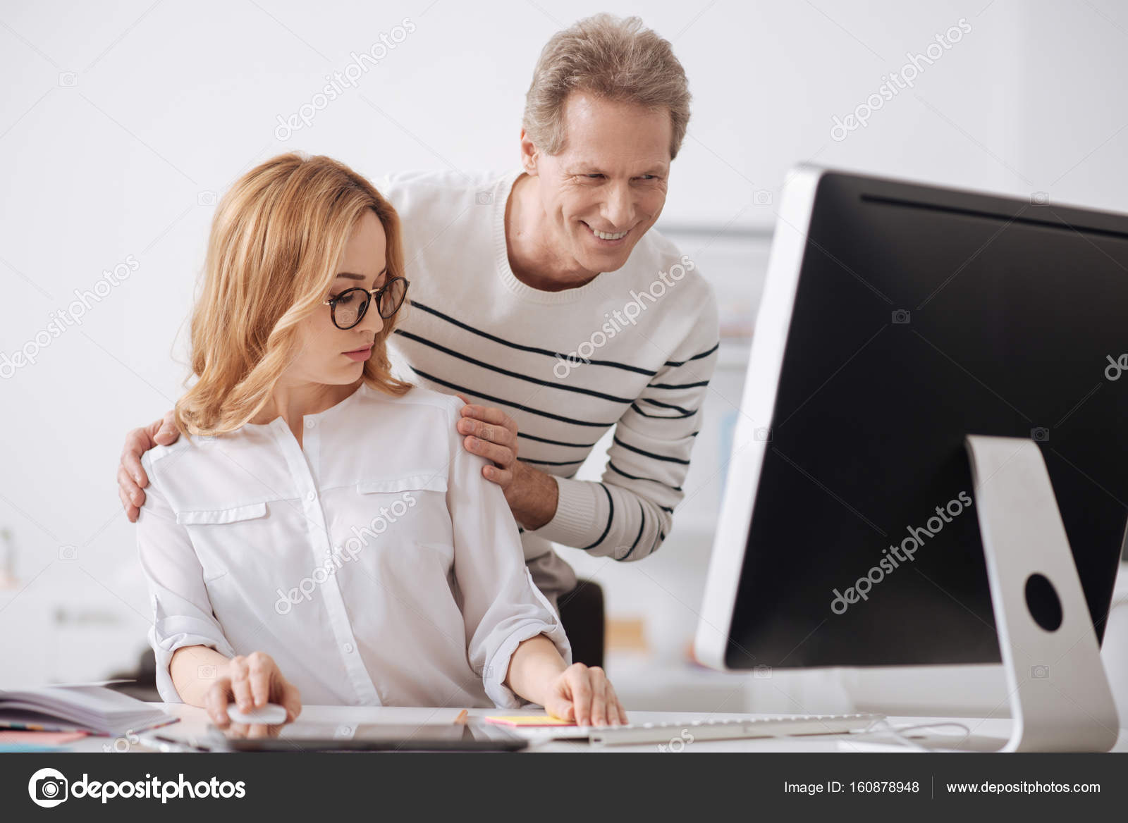 Young office manager collaborating with senior colleague at work ...