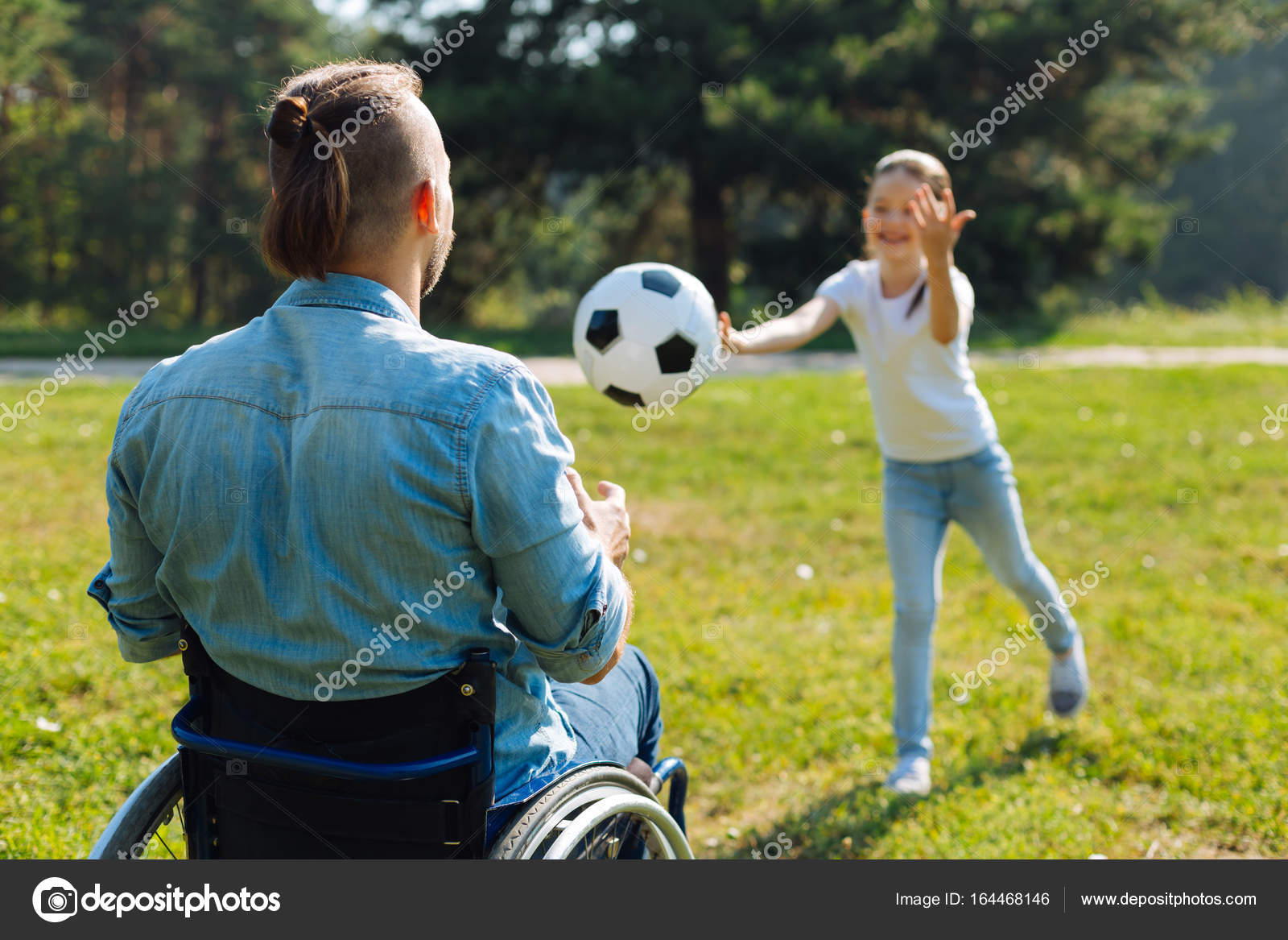 Incapacitated young man catching ball thrown by daughter Stock Photo by ...