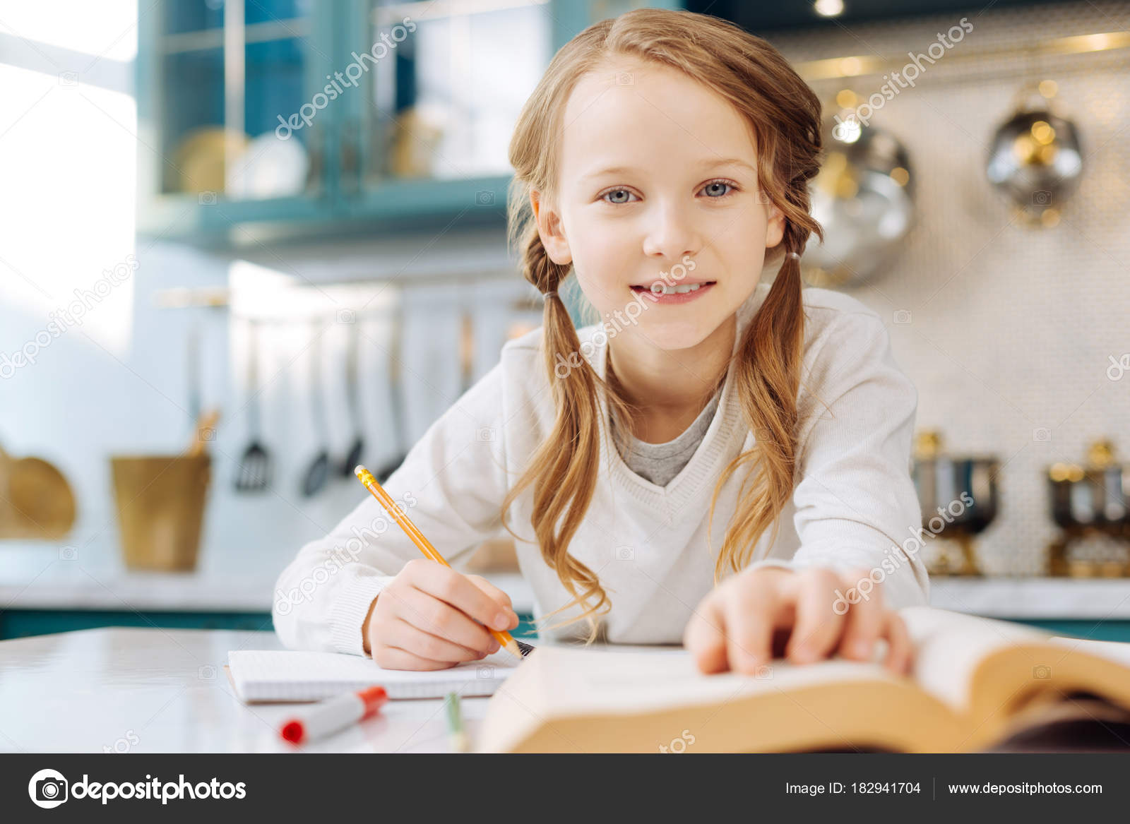 Glad child sitting with her notebook and a book — Stock Photo © Dmyrto ...