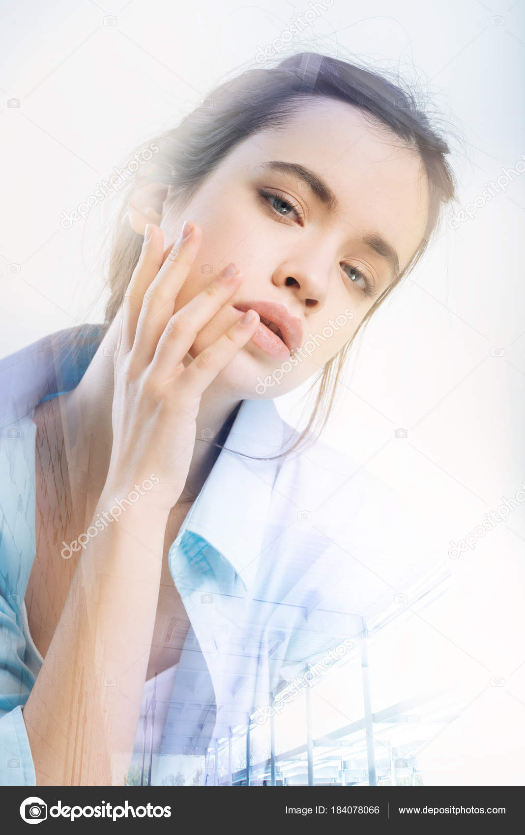 Sensitive woman touching her face and looking in front of herself ...