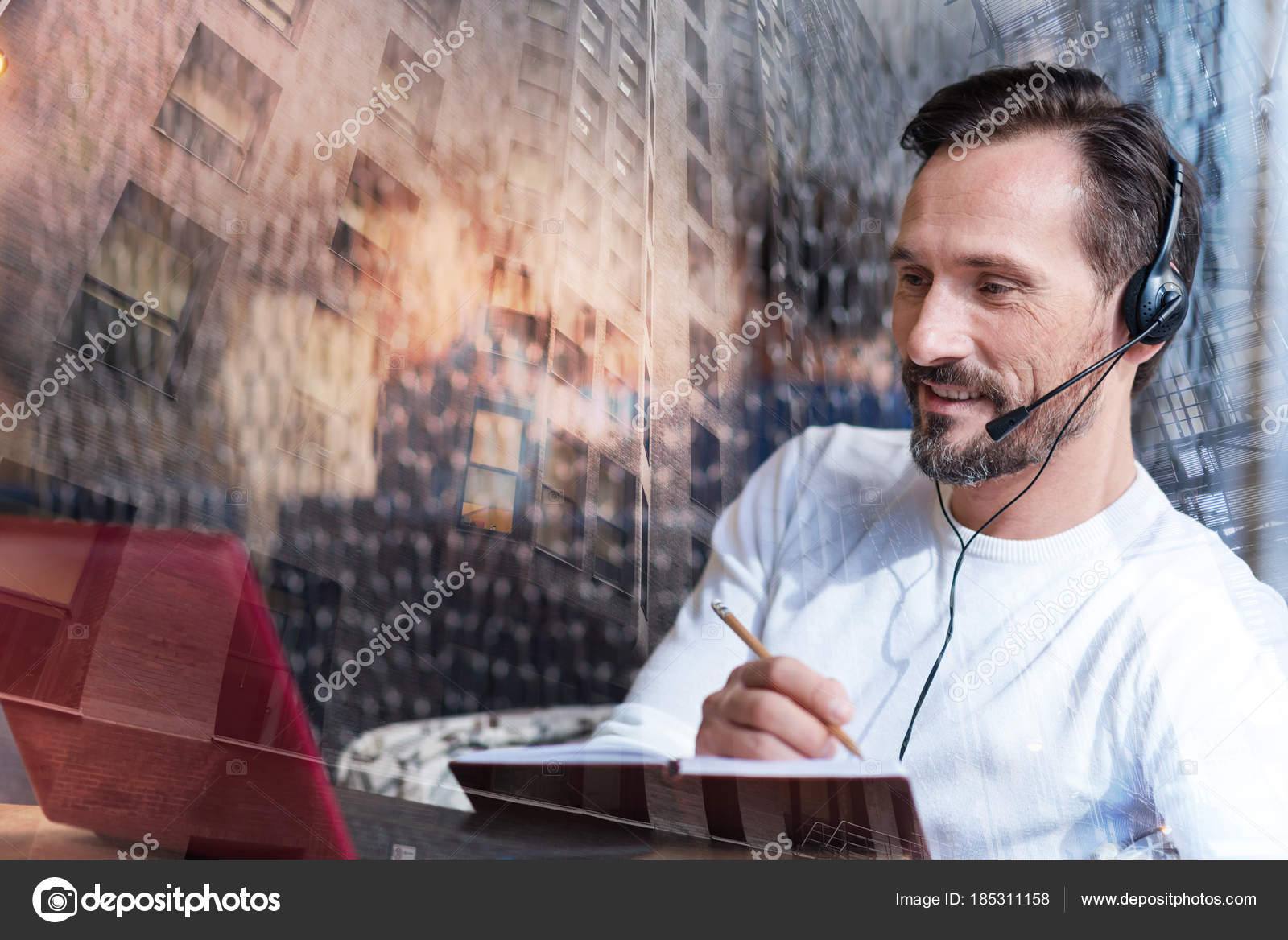 Pleasant man watching video tutorial and making notes Stock Photo by ...