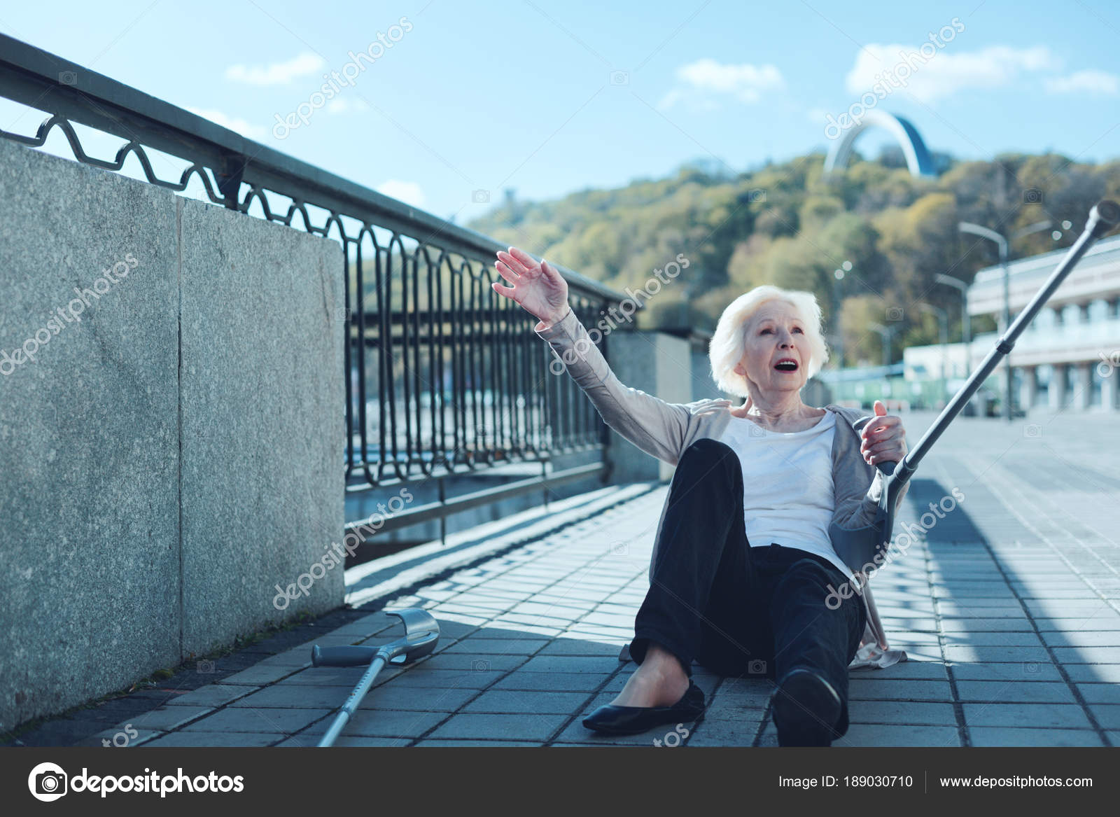 Scared retired lady with crutches falling while promenading Stock Photo ...
