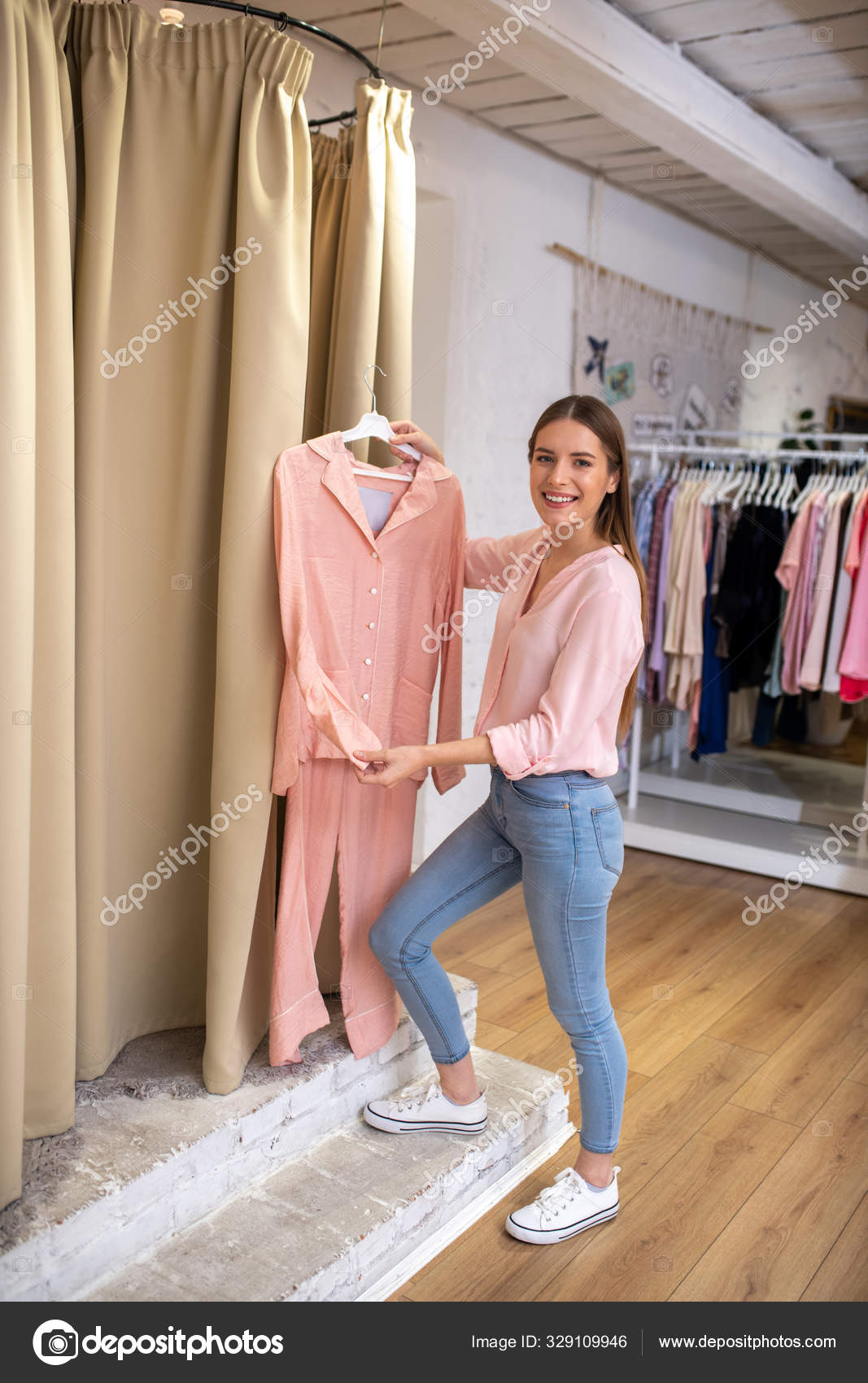 Shop assistant holding a costume near the fitting room Stock Photo by ...