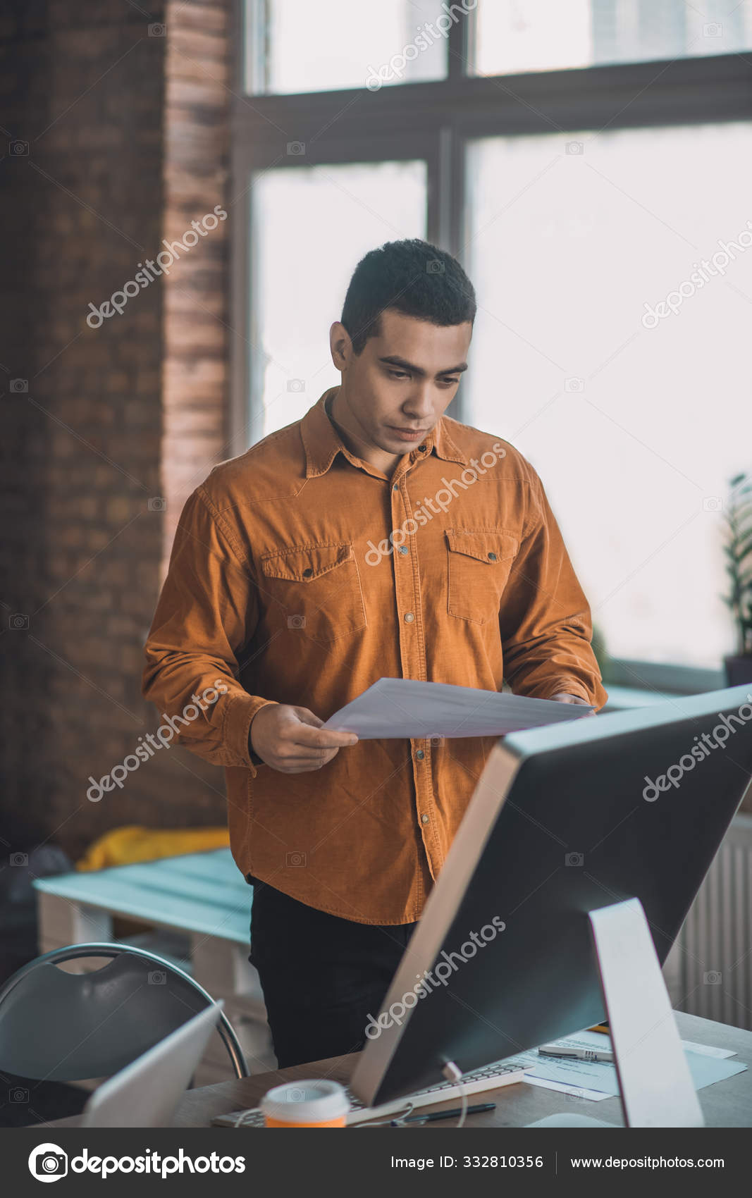 Good looking intelligent man standing near his desk — Stock Photo ...
