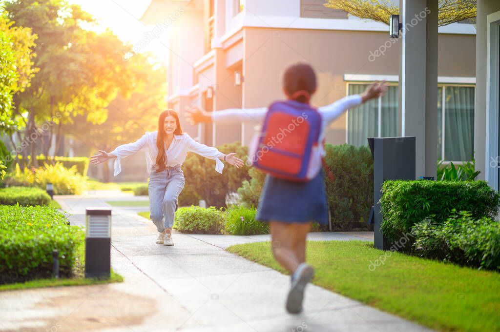 la mamá la bienvenida a casa de la hija de vuelta de la escuela en el ...
