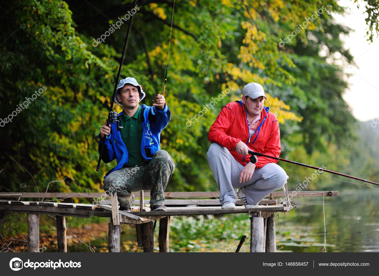 Two fishermen catch fish standing on the bridge Stock Photo by ...
