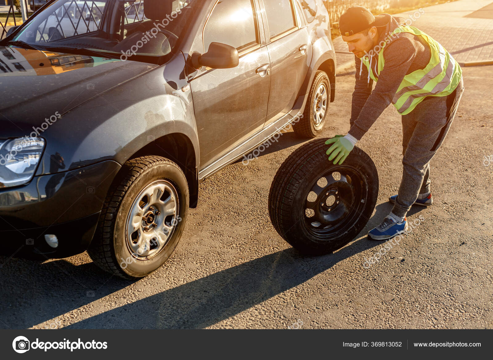 The driver should replace the old wheel with a spare. Man changing ...