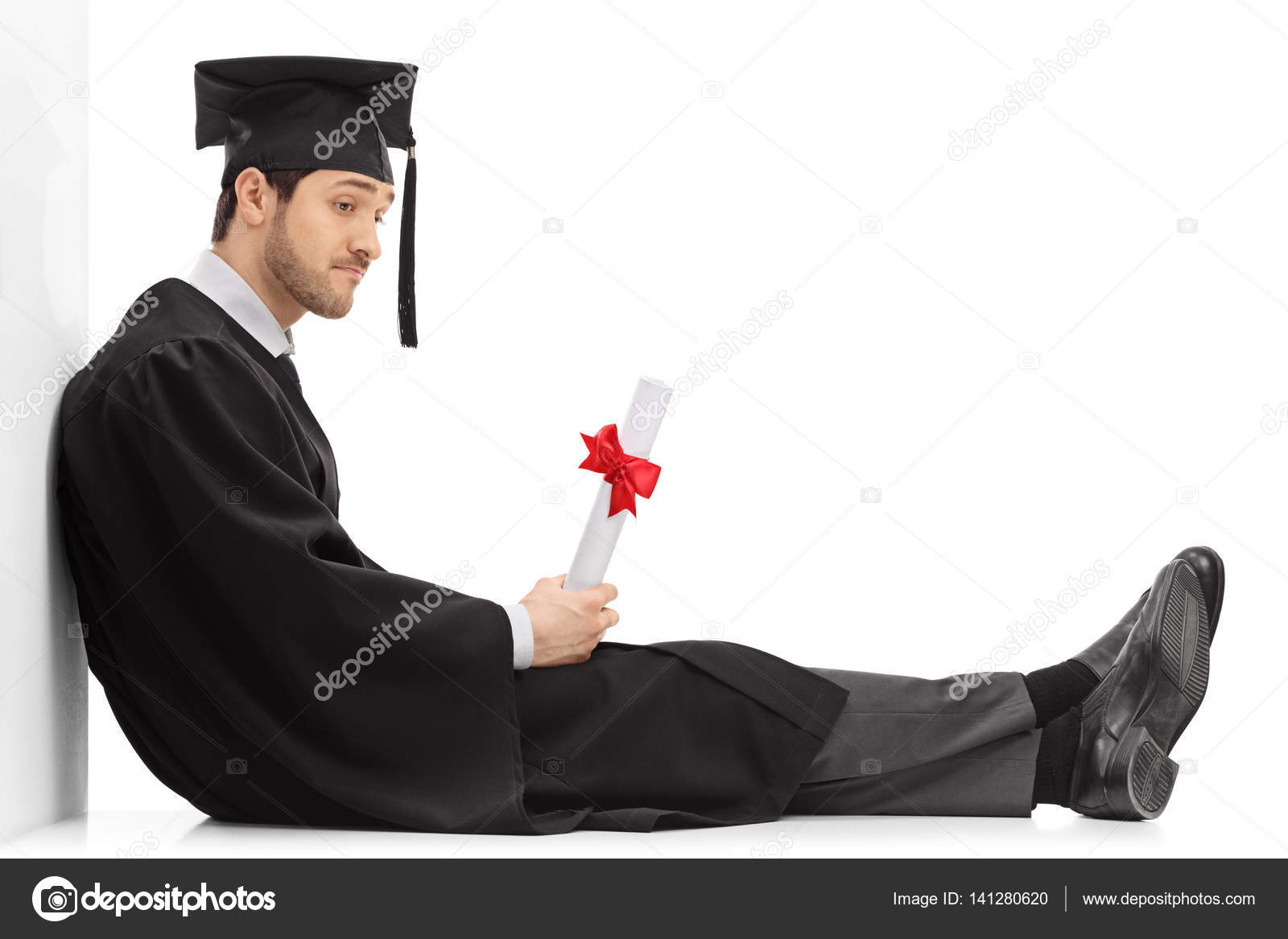 Triste estudiante graduado con un diploma sentado en el suelo — Foto de ...