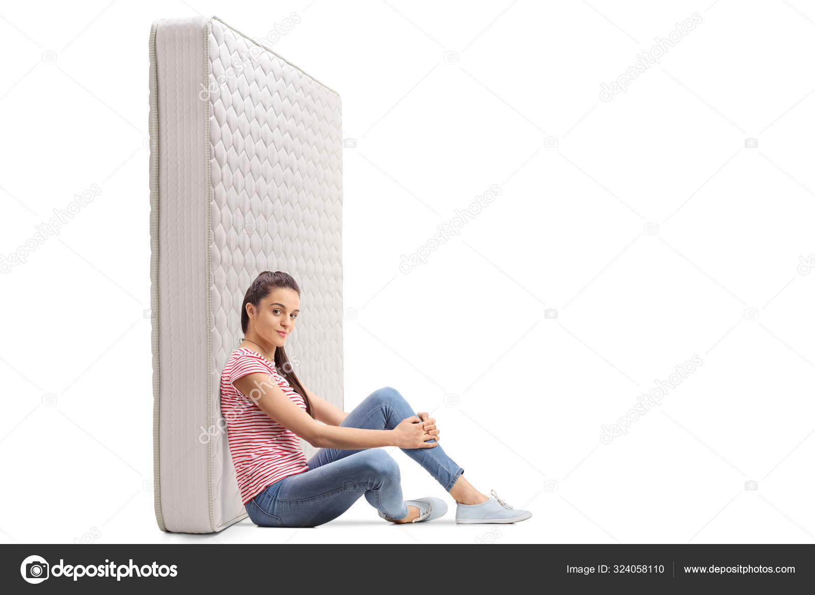Young female sitting on the floor and leaning on a bed mattress Stock ...