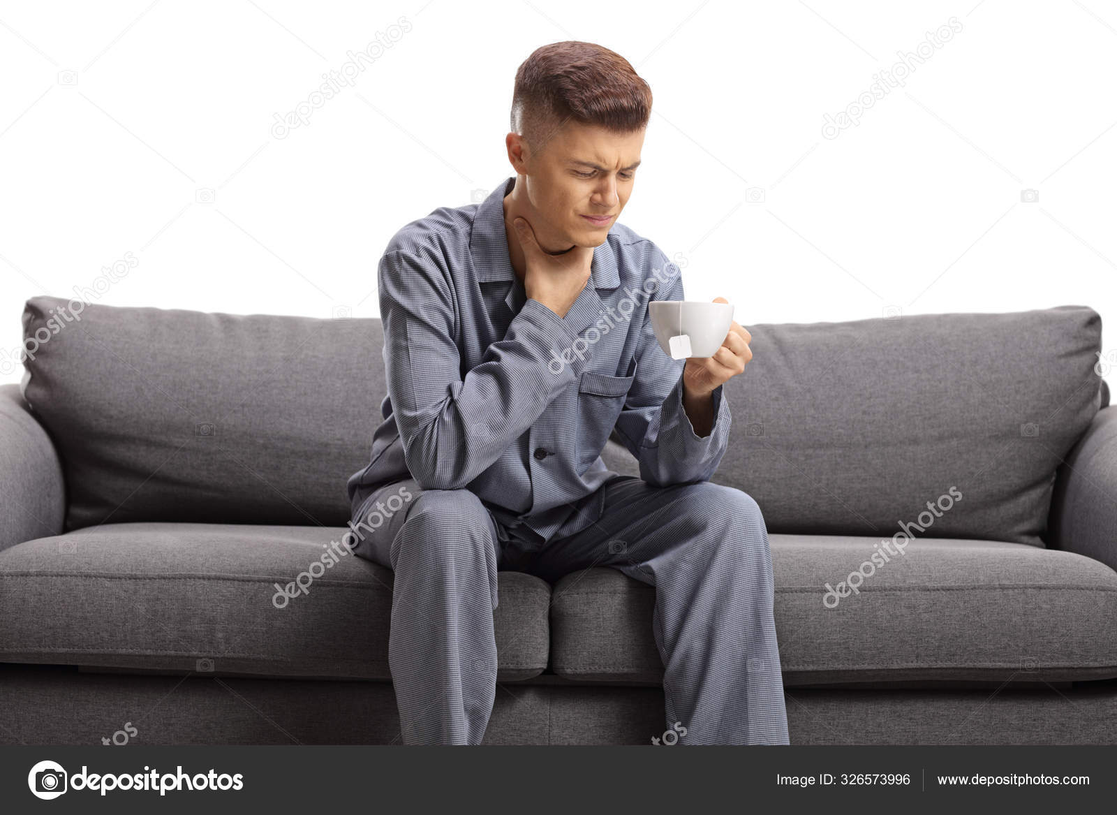 Young guy suffering from sore throat sitting on a sofa with a cu Stock ...