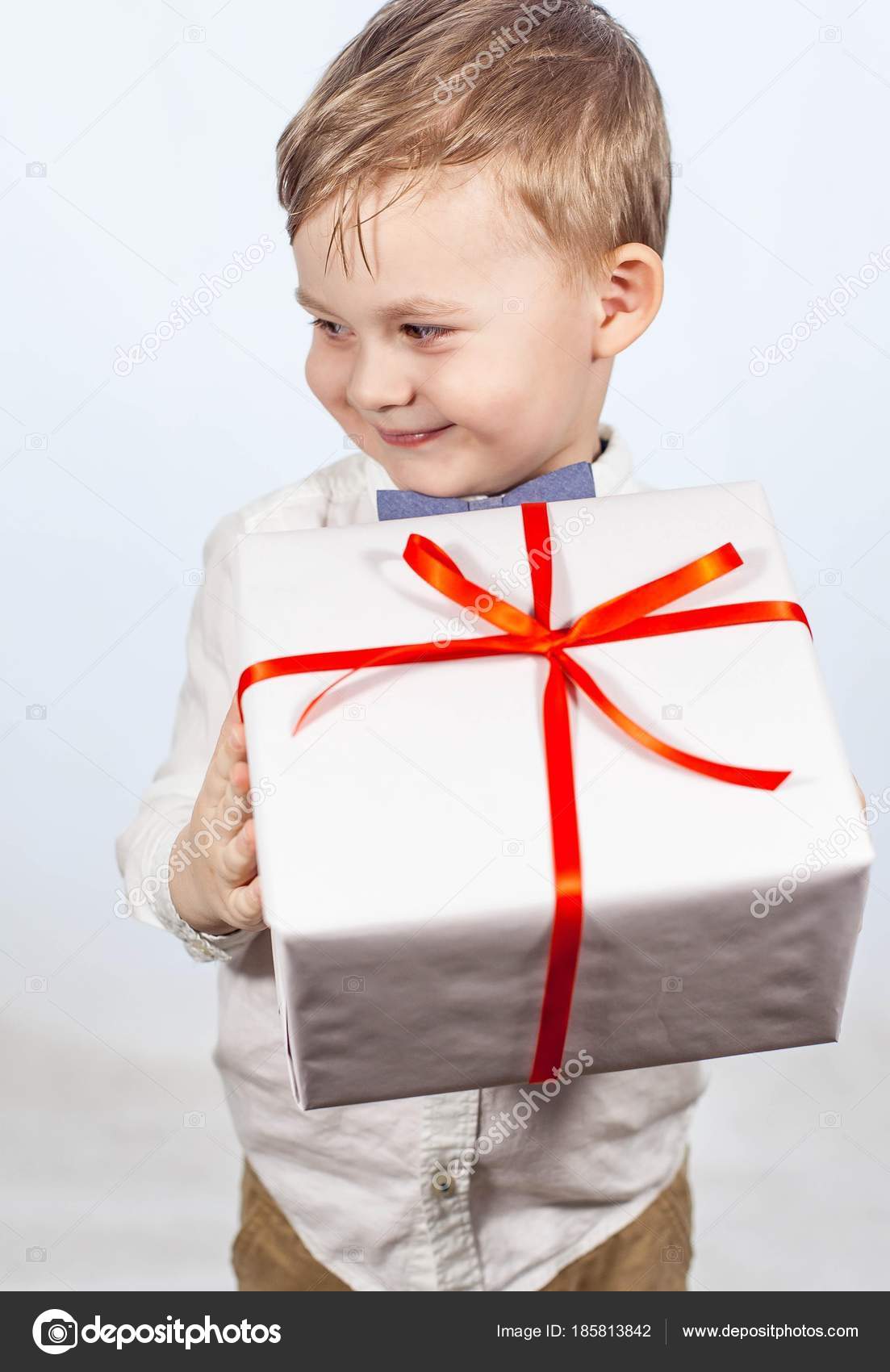 Cute little boy with a gift. Happy boy holding a box with a gift ...