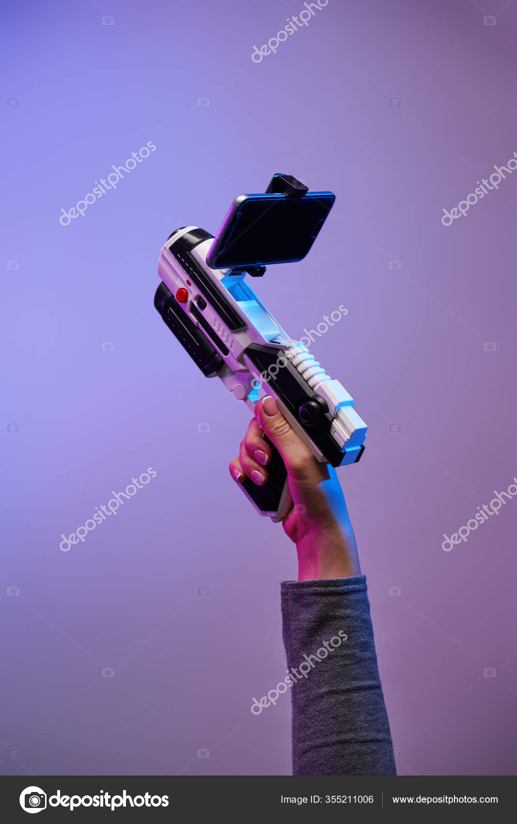 Female hands with a blaster for games with augmented reality on a ...