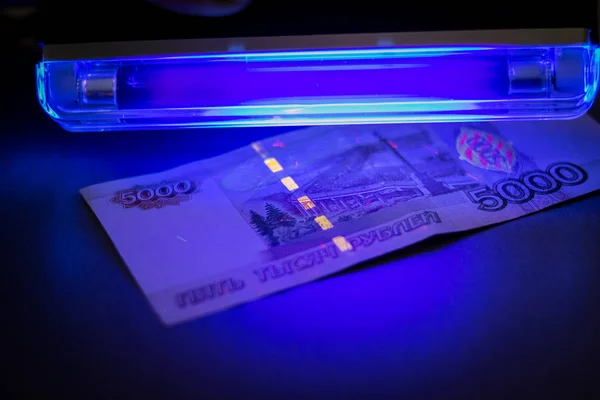100 Euro banknote. Lying in the ultraviolet to verify the authenticity ...