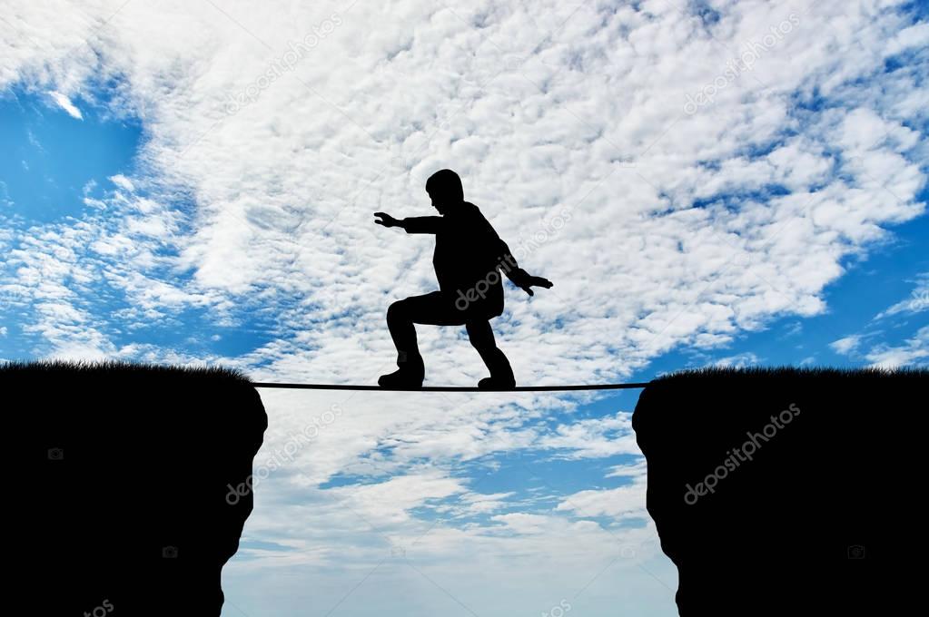 Man walks on a tightrope over a cliff — Stock Photo © Prazisss #139892630