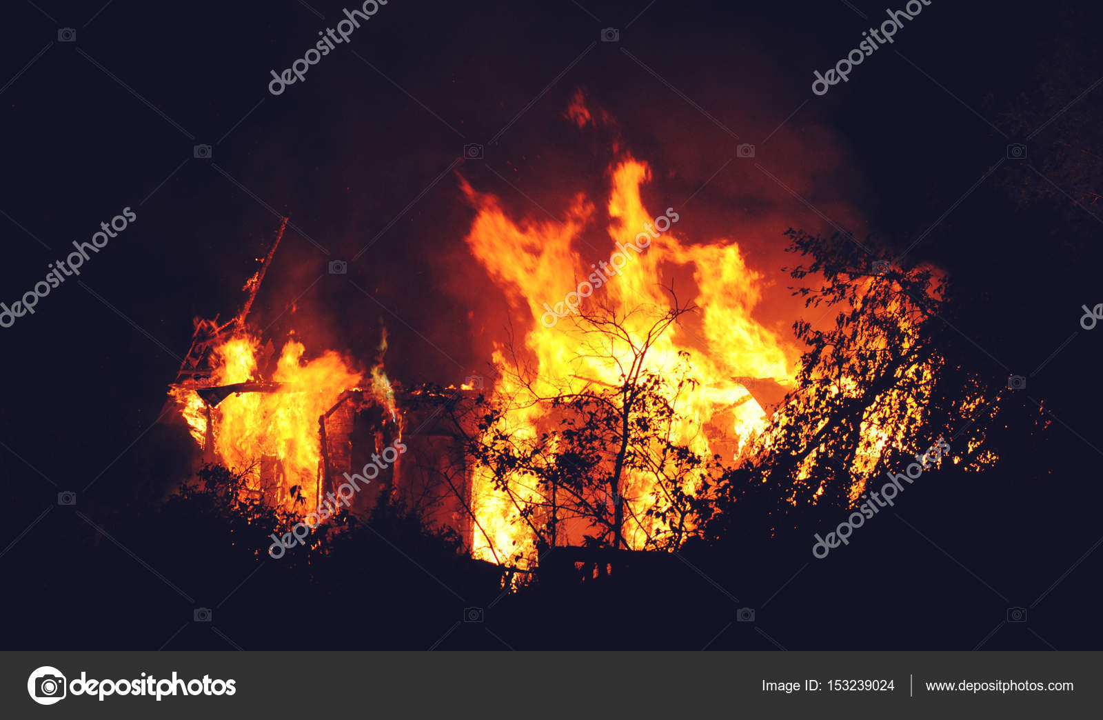 Arson or nature disaster - burning fire flame on wooden house roof. Big ...