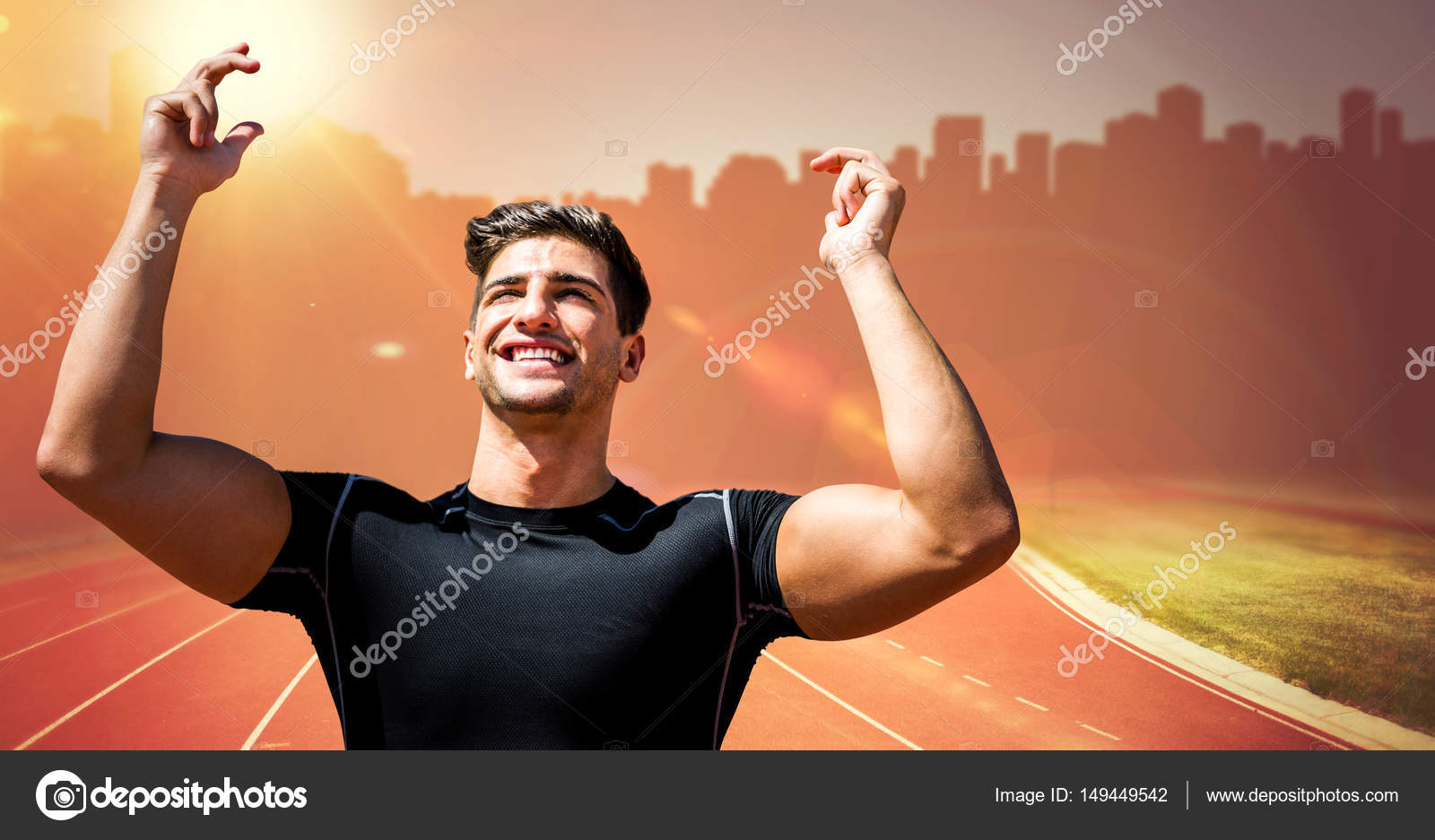 Male runner with hands in air on track against orange flare and blurry ...