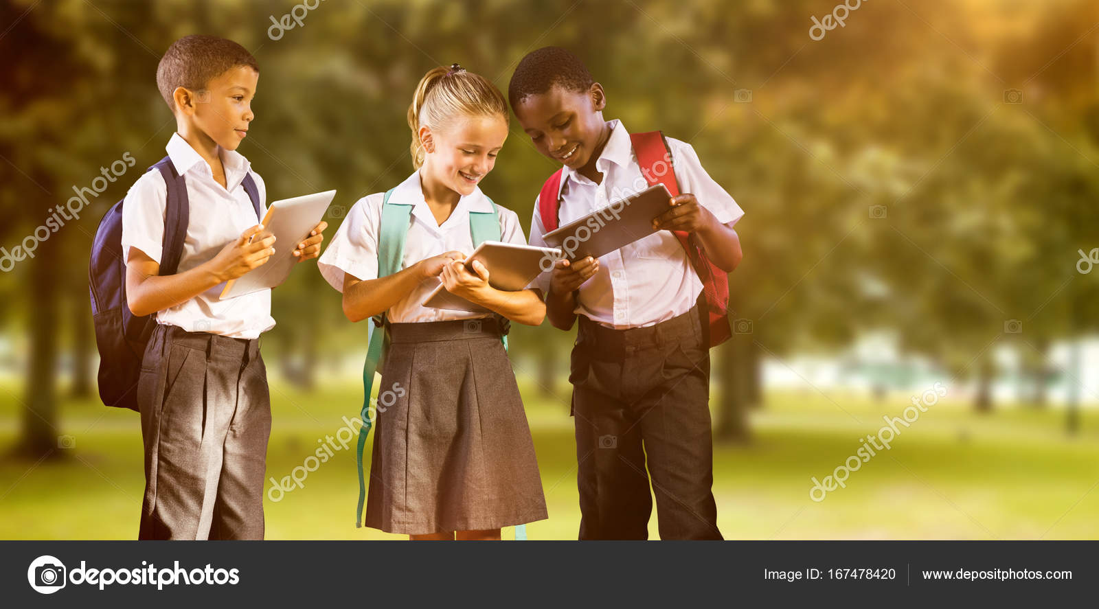 Students in uniforms using digital tablets Stock Photo by ...