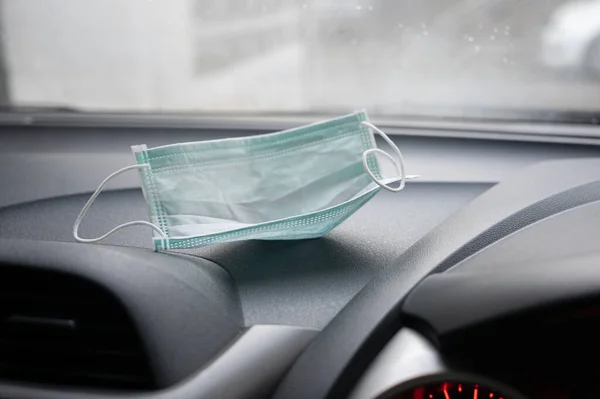 Medical face mask placed on the car console. concept To protect against ...