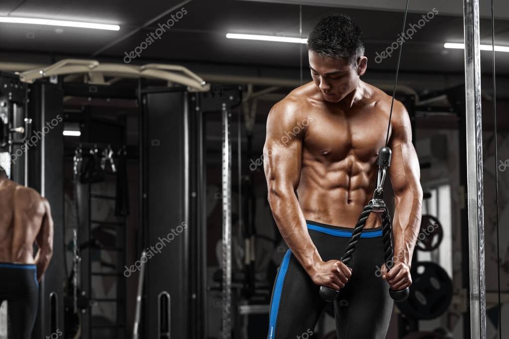 Hombre musculoso haciendo ejercicio en el gimnasio haciendo ejercicios ...