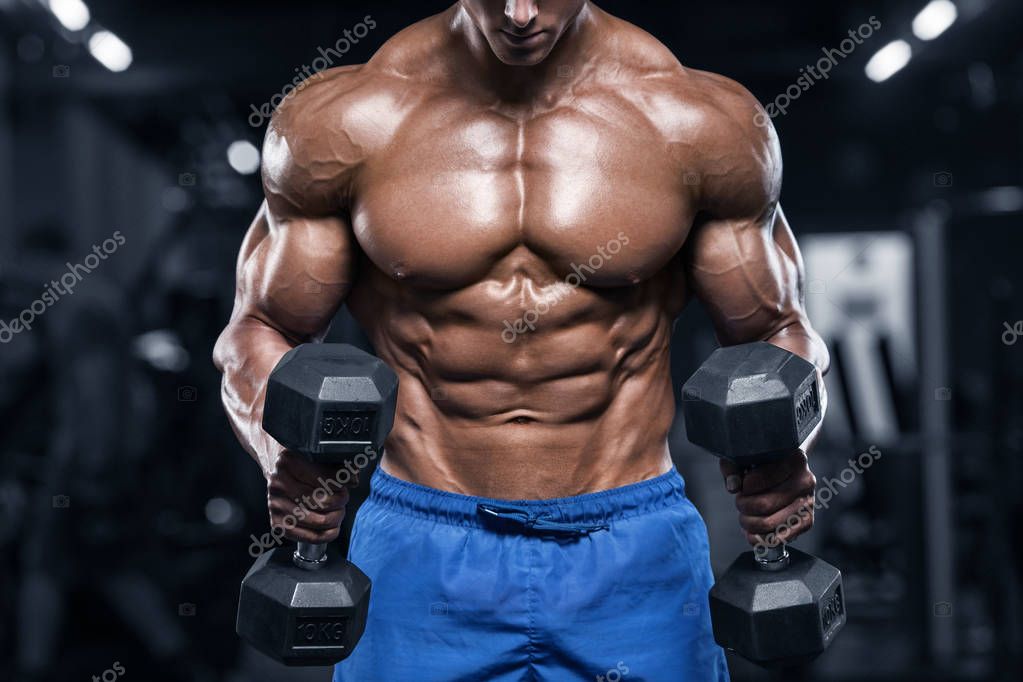 Hombre musculoso haciendo ejercicio en el gimnasio haciendo ejercicios ...