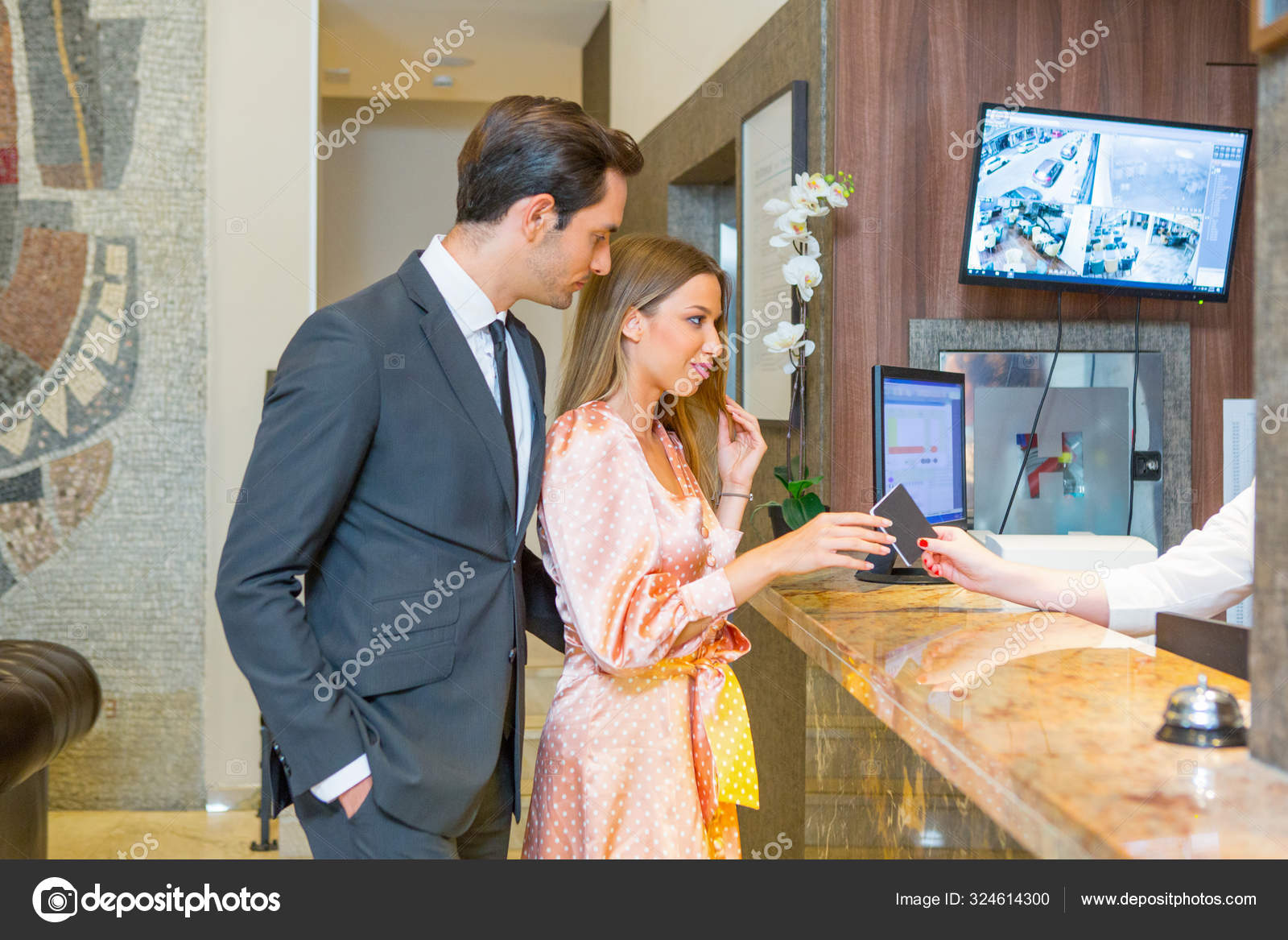 Attractive couple checking in at the hotel reception — Stock Photo ...