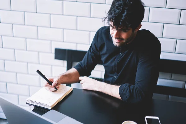 Positive student writing down records during watching business webinar ...