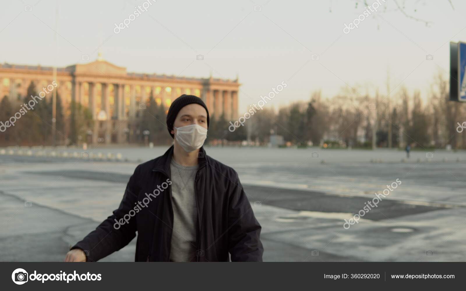Young man in protective mask close up, portrait empty street area ...