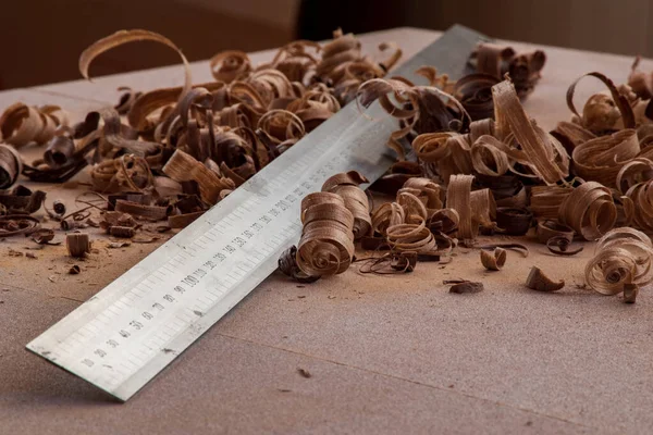 a steel metric ruler in wood chips on the table - Stock Image - Everypixel