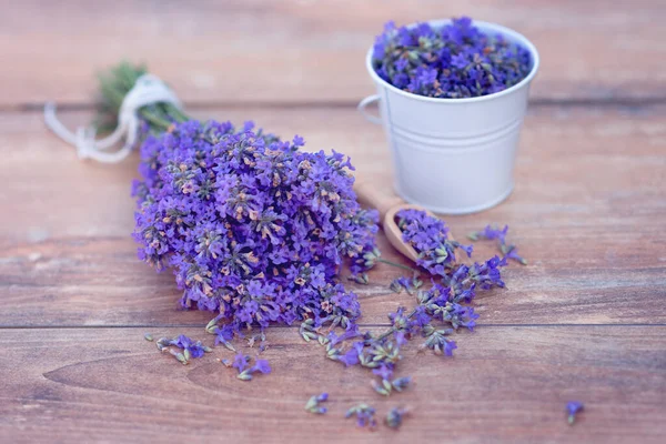 Fresh bouquet of lavender and a bucket full of lavender on brown wooden ...