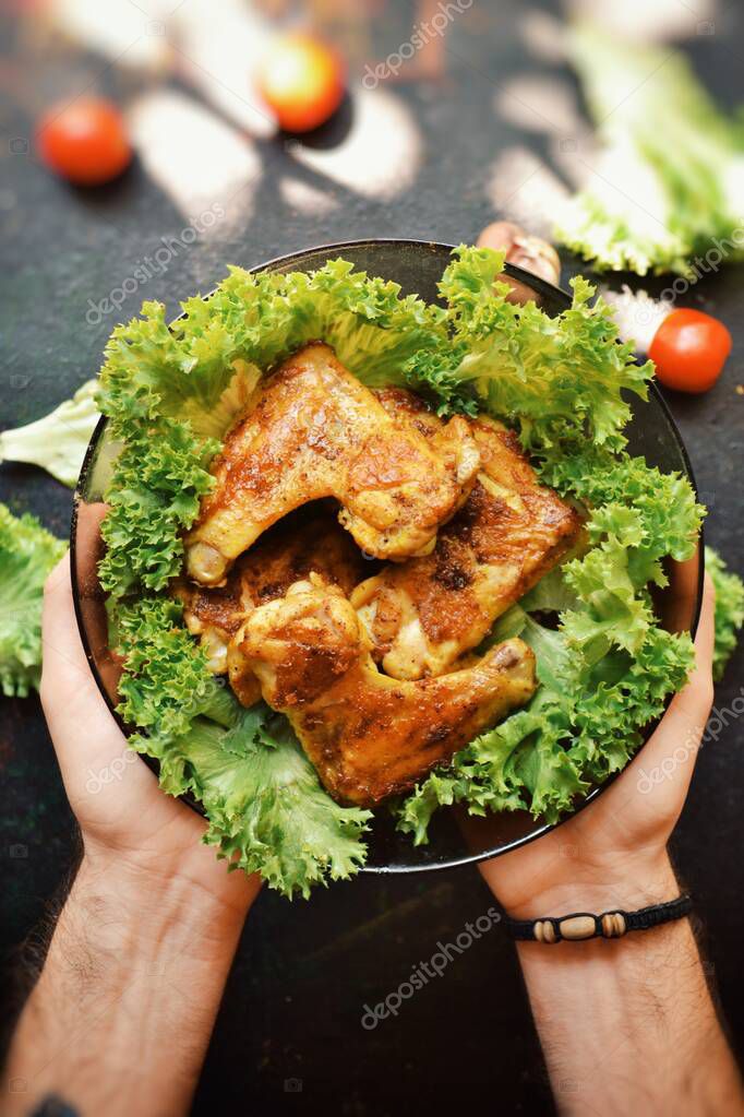 Alitas de pollo con lechuga en un plato sobre un fondo azul claro ...