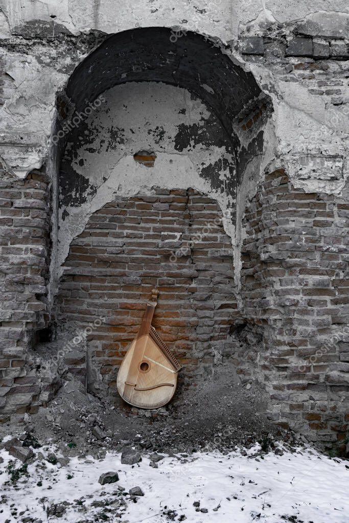 Una bandura de color árbol junto al arco en una pared de piedra en ...