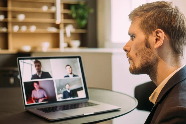Young man having a Zoom video conference call via computer. Home office ...