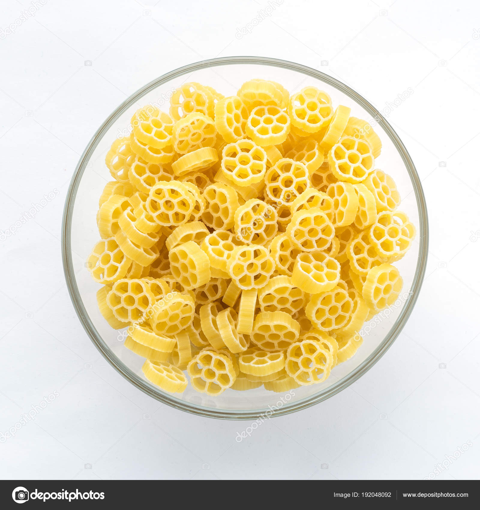 Macaroni ruote pasta in glass bowl on white isolated background, in the ...